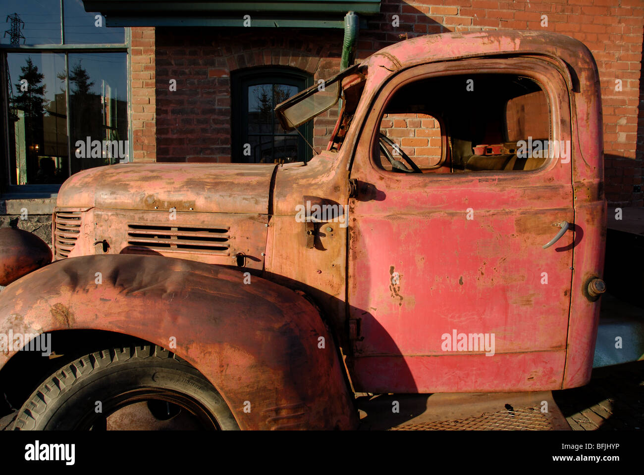 A side view of an old rusted and abandoned red 1947 Fargo pickup truck ...