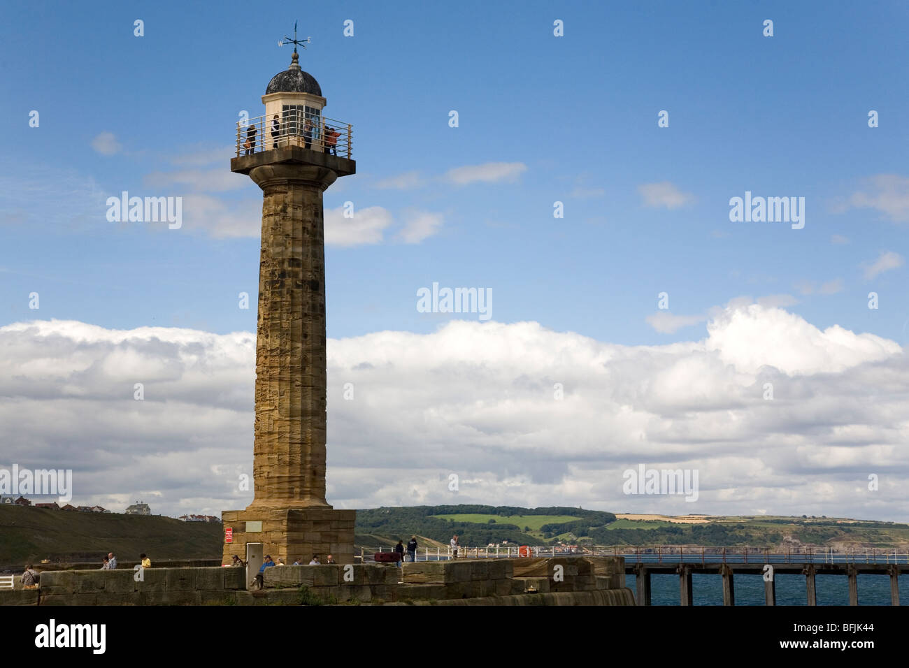 The old stone lighthouse on the West Pier of Whitby in North Yorkshire ...