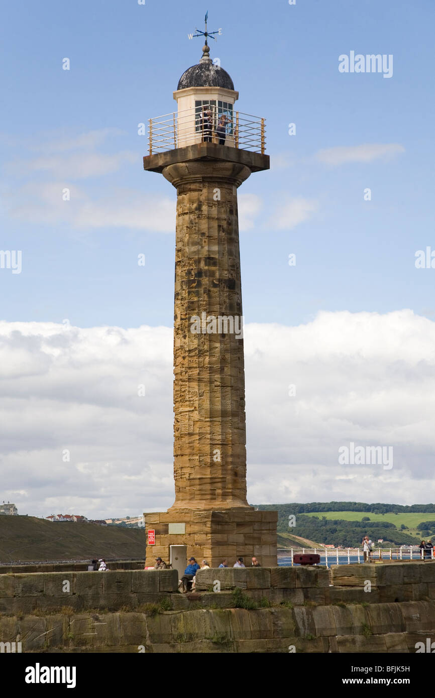 The old stone lighthouse on the West Pier of Whitby in North Yorkshire ...