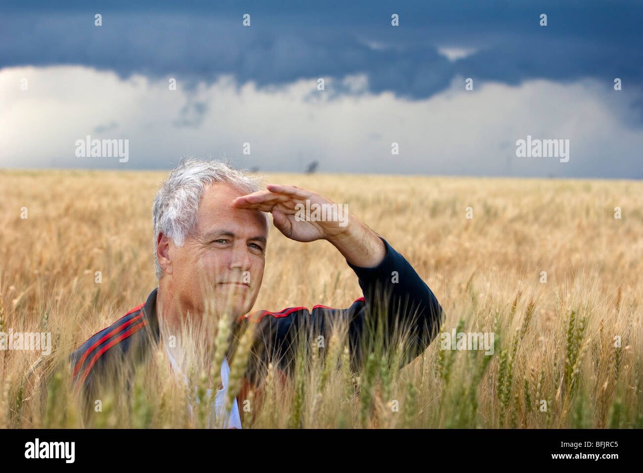 Storm chaser Tim Marshall in a prairie field in western Kansas, USA ...