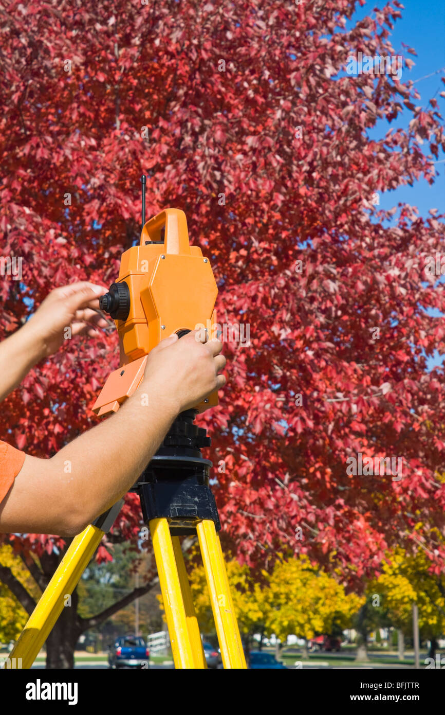 Hands on theodolite - land surveying during fall time Stock Photo - Alamy