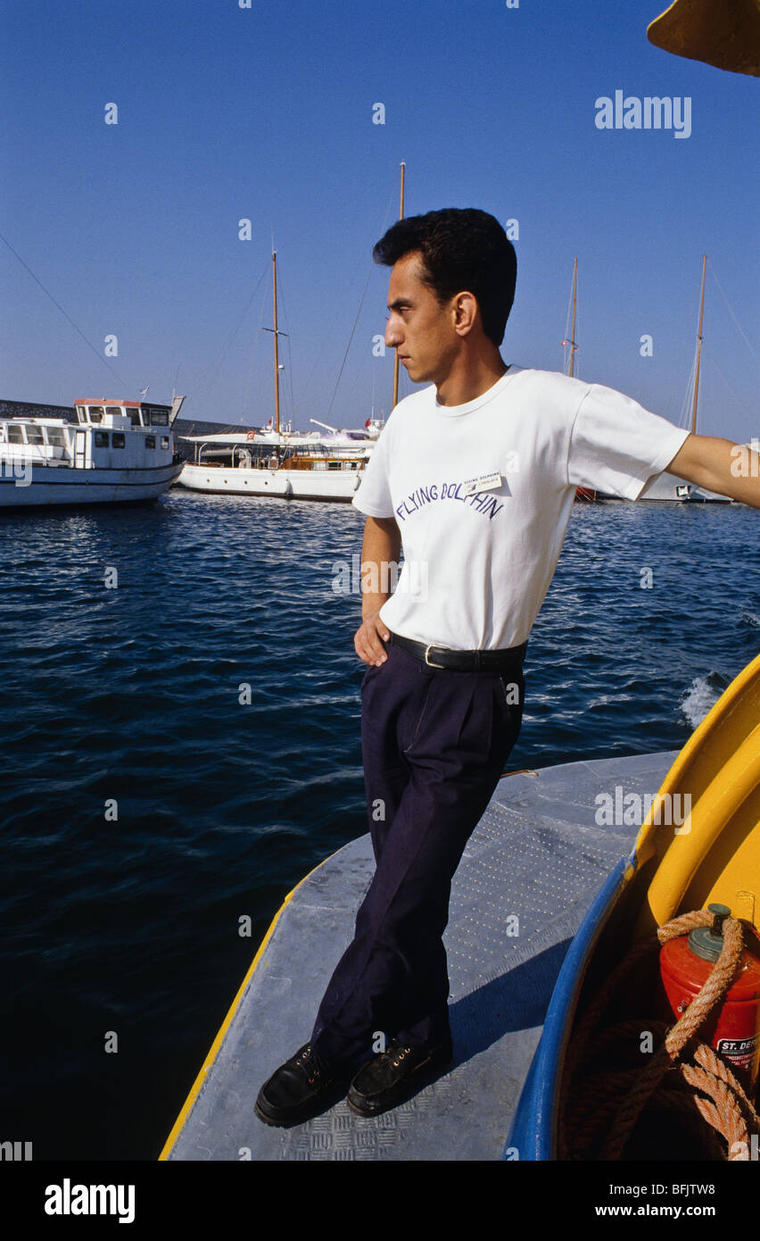 Greek ferry crew member stands on deck as the ship crosses from the ...