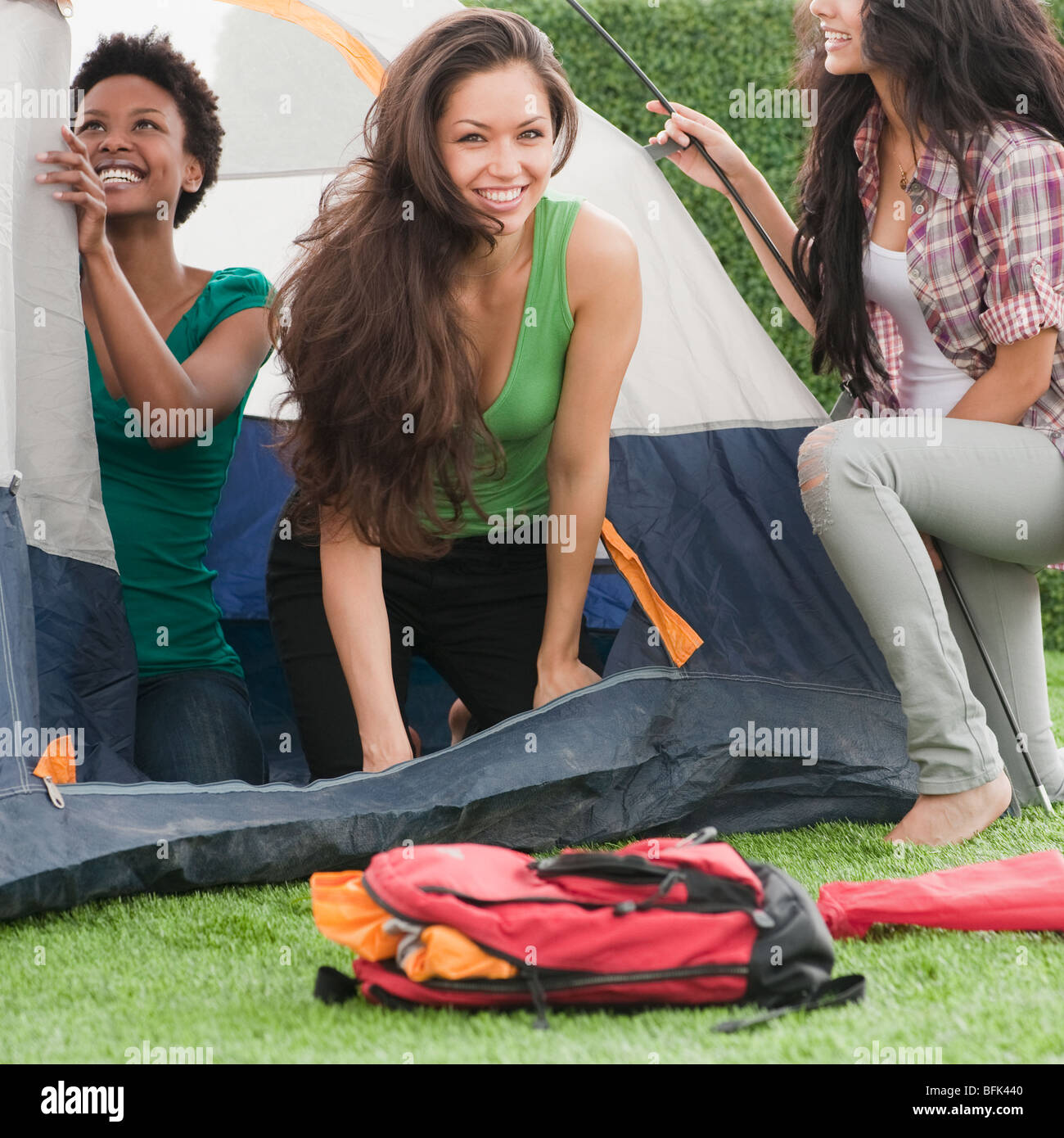 Friends putting up tent Stock Photo - Alamy