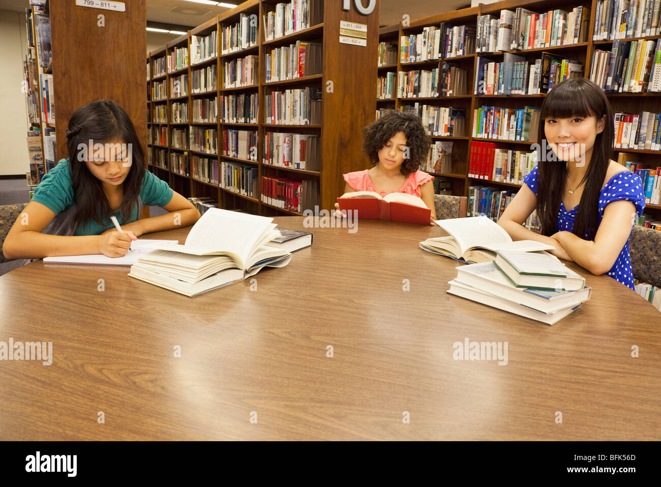 Girls doing homework in library Stock Photo - Alamy