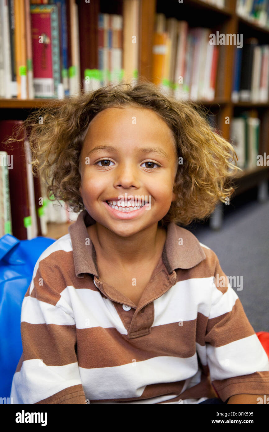 Boy smiling in library Stock Photo - Alamy