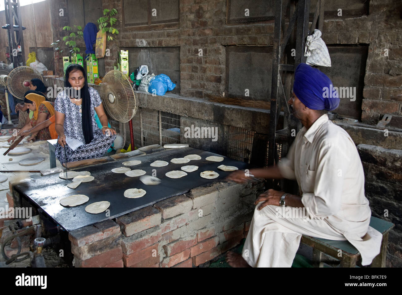 Man and woman making chapatis (Indian bread). The Golden Temple kitchen ...