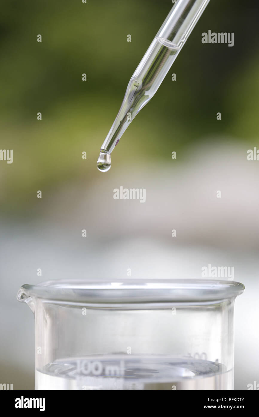 Pipette dropping liquid into beaker Stock Photo - Alamy