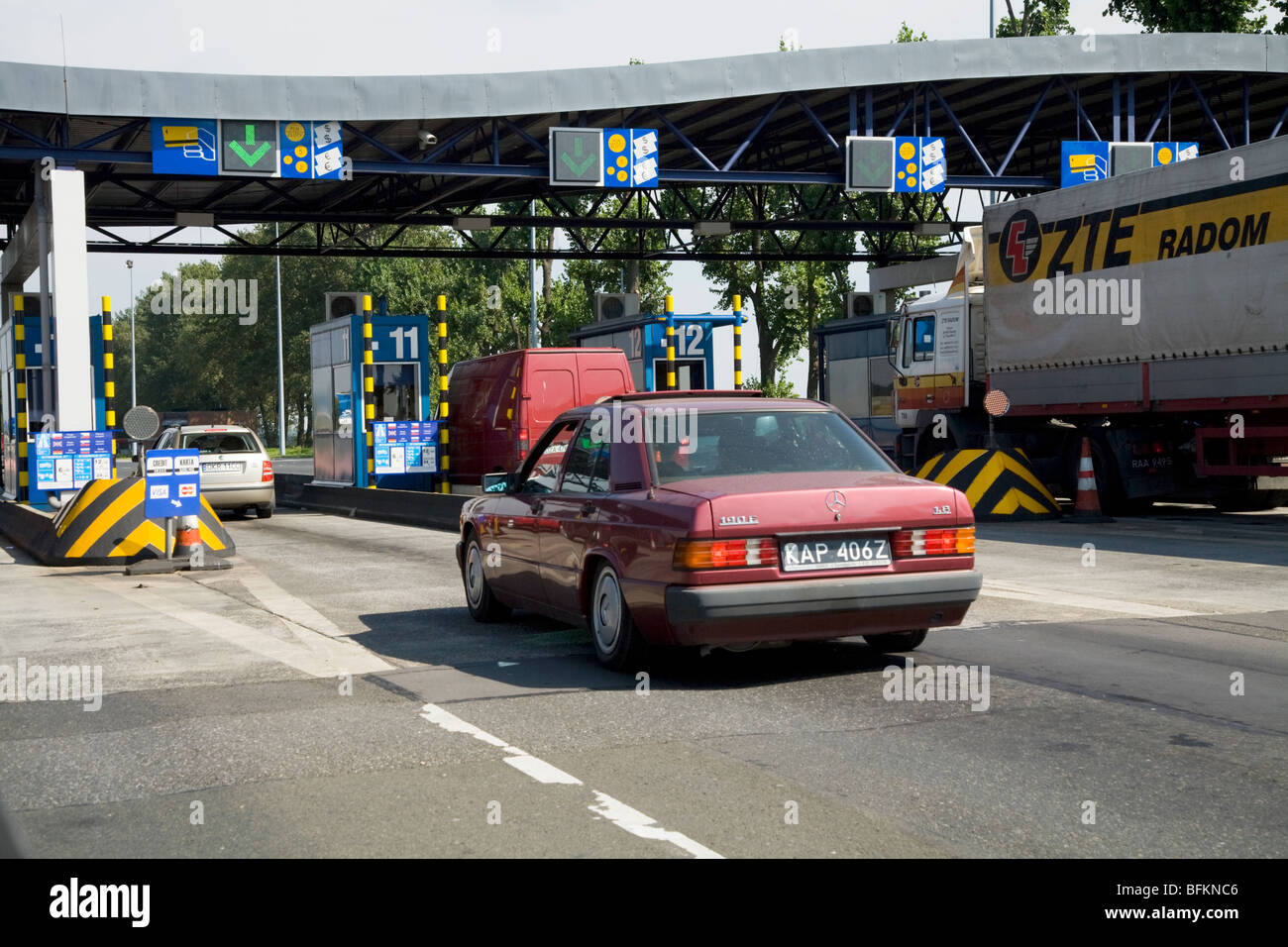 Car and other vehicles approach a Polish motorway toll booth. Near ...