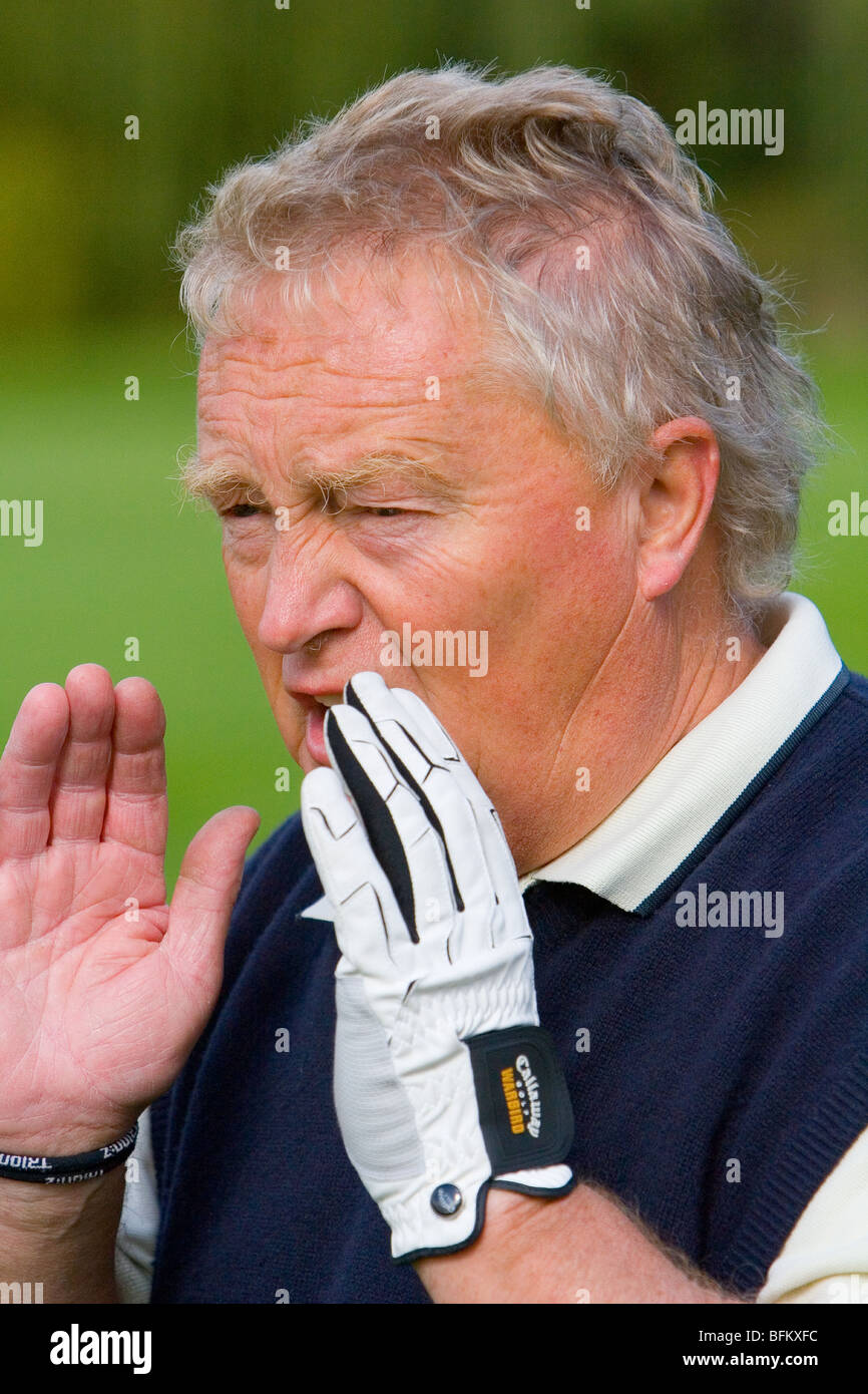 A senior white male playing golf shouting fore after taking a shot ...