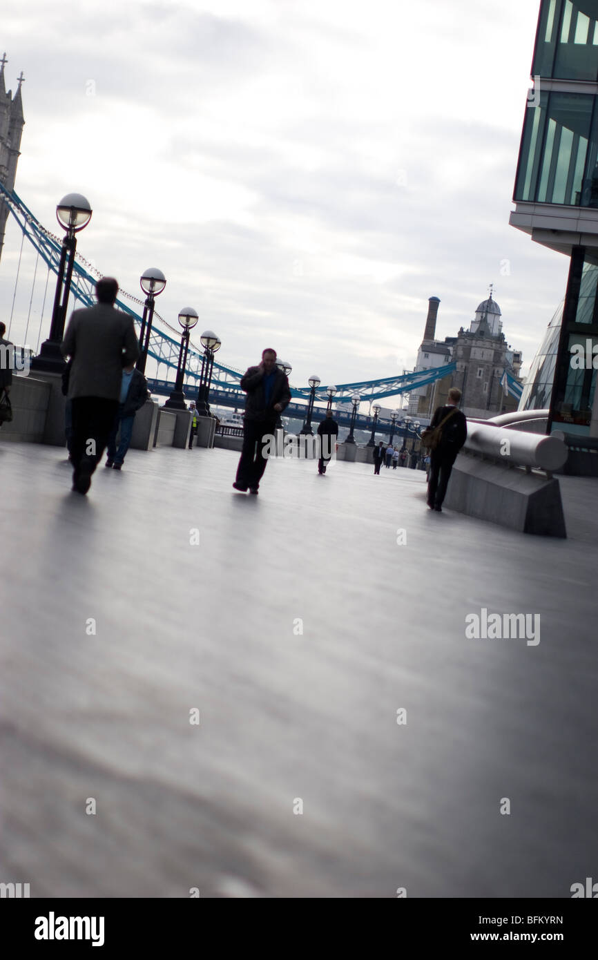 Pedestrians make their way along Queens Walk beside the River Thames ...