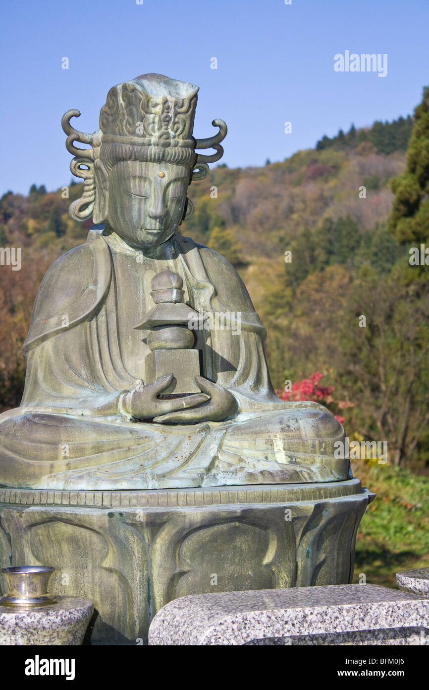 A statue of Buddha with a mountainside forest in the background Stock ...