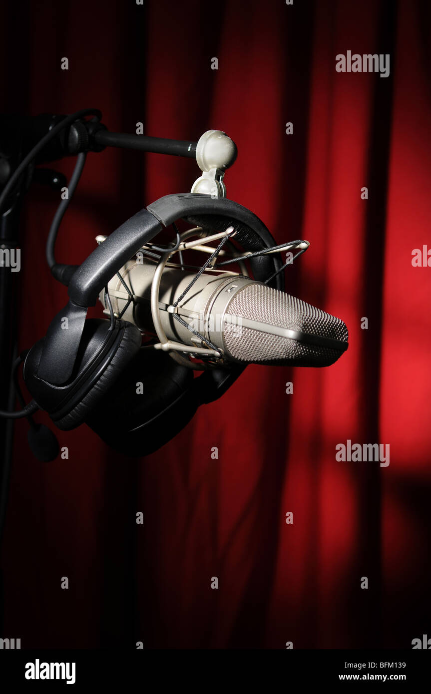 Vintage microphone and headphones over a red curtain with spotlight ...