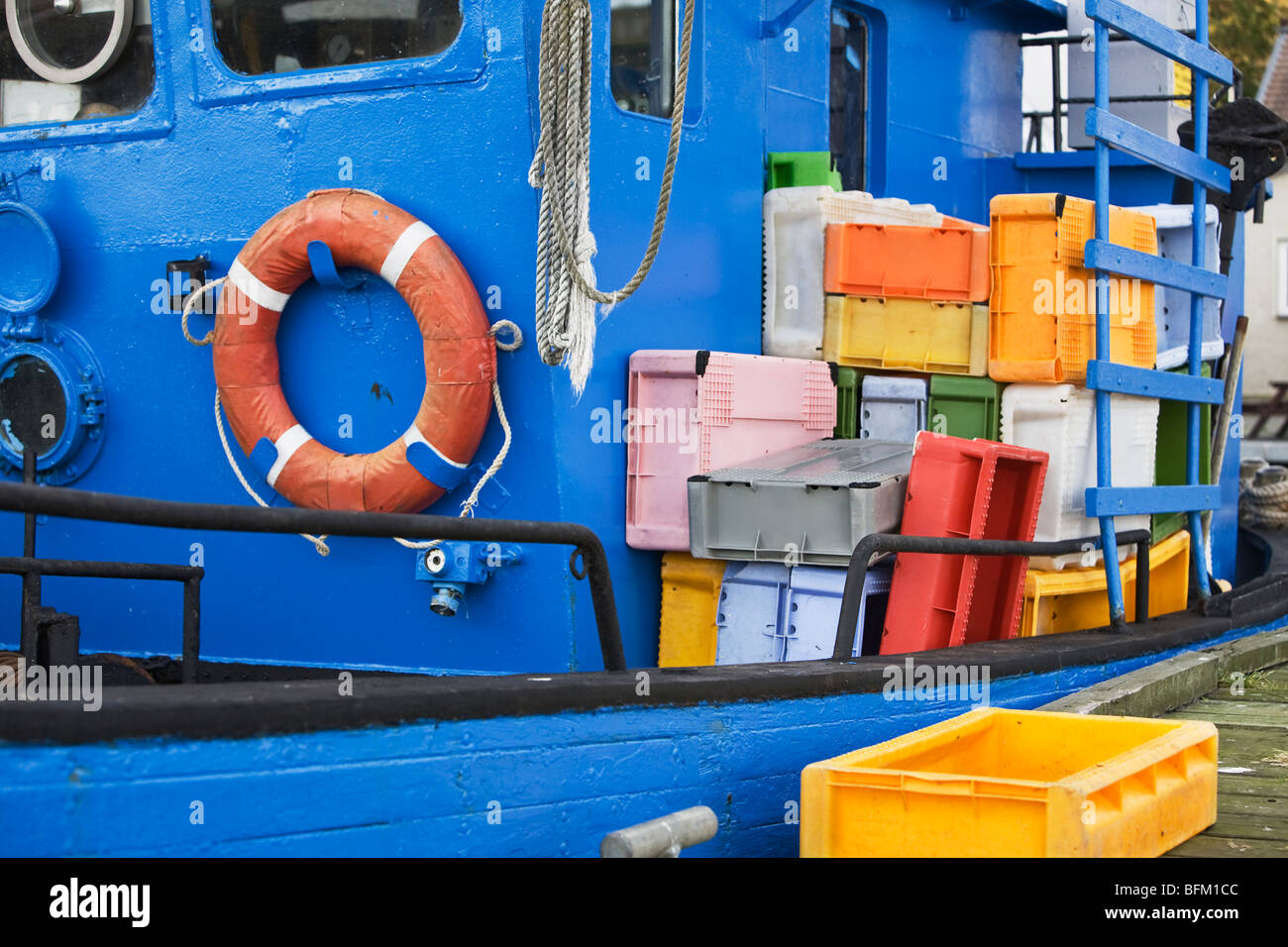 Fish cutter with colorful shipping containers and life belt Stock Photo ...