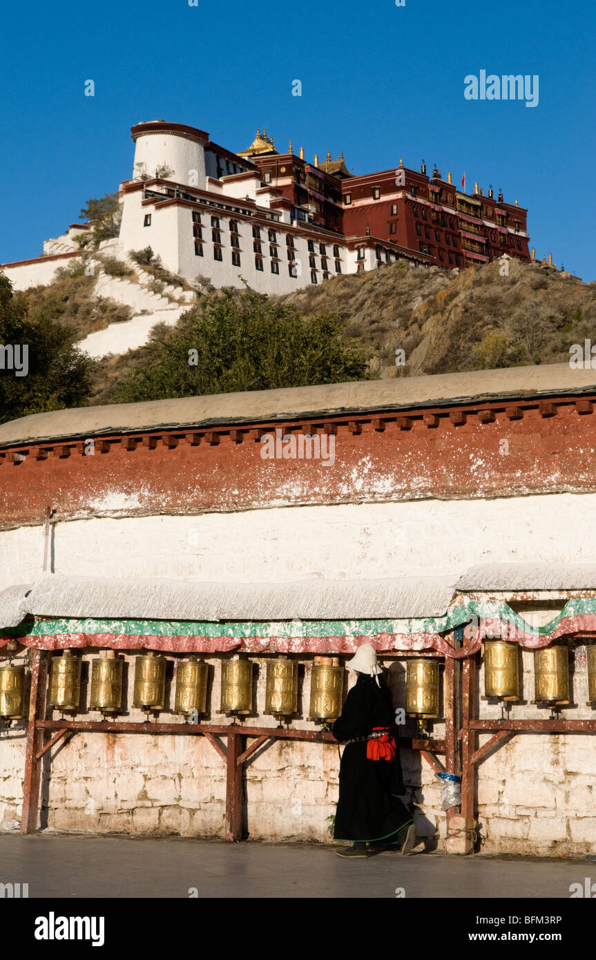 A Tibetan pilgrim walks around the Potala Palace in Lhasa Tibet while ...