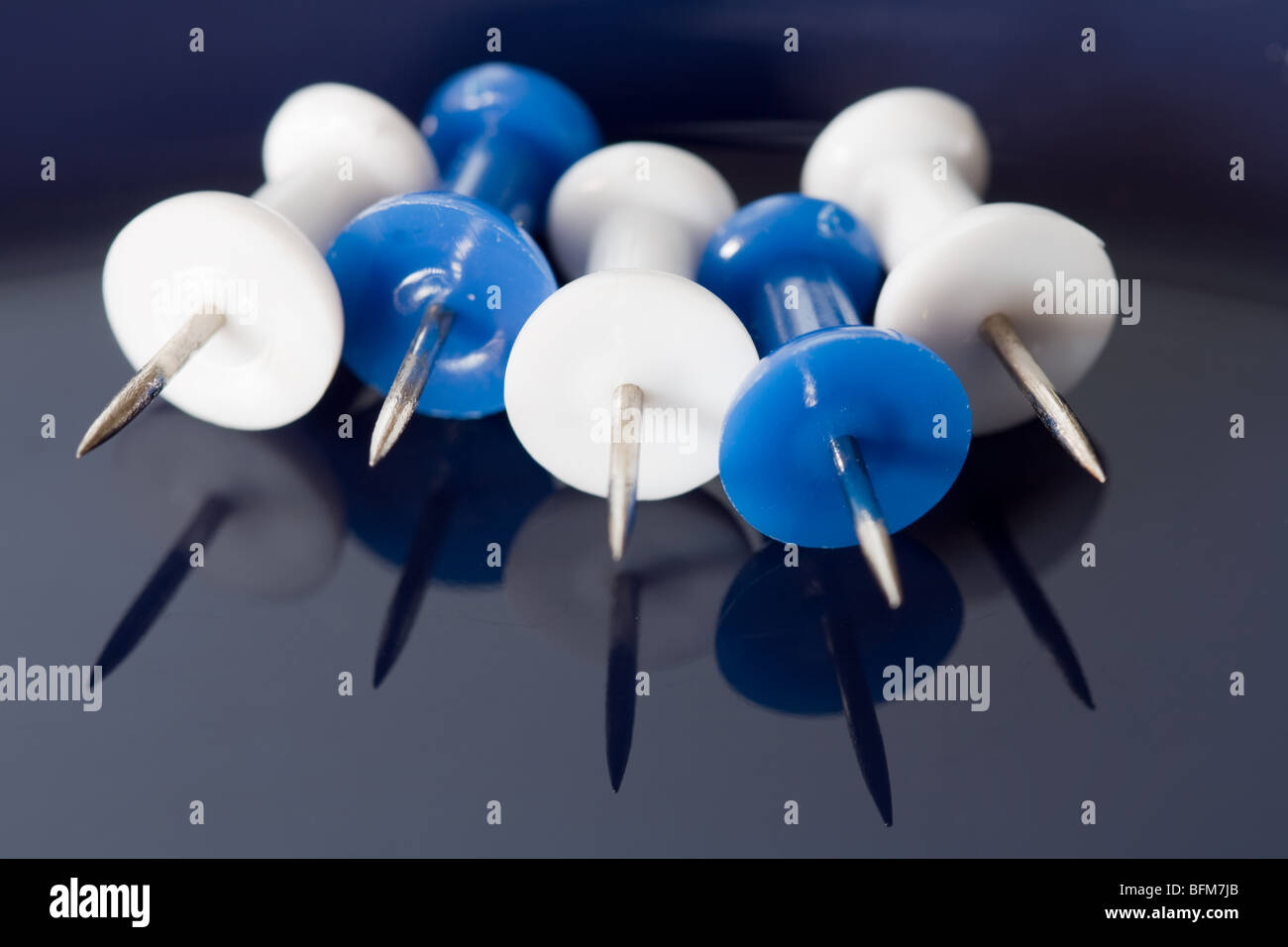 Blue and White push pins on a shiny blue background Stock Photo - Alamy