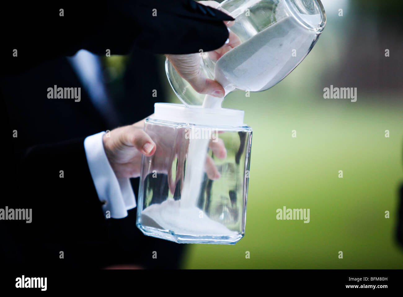 hand pouring sand into jar Stock Photo - Alamy