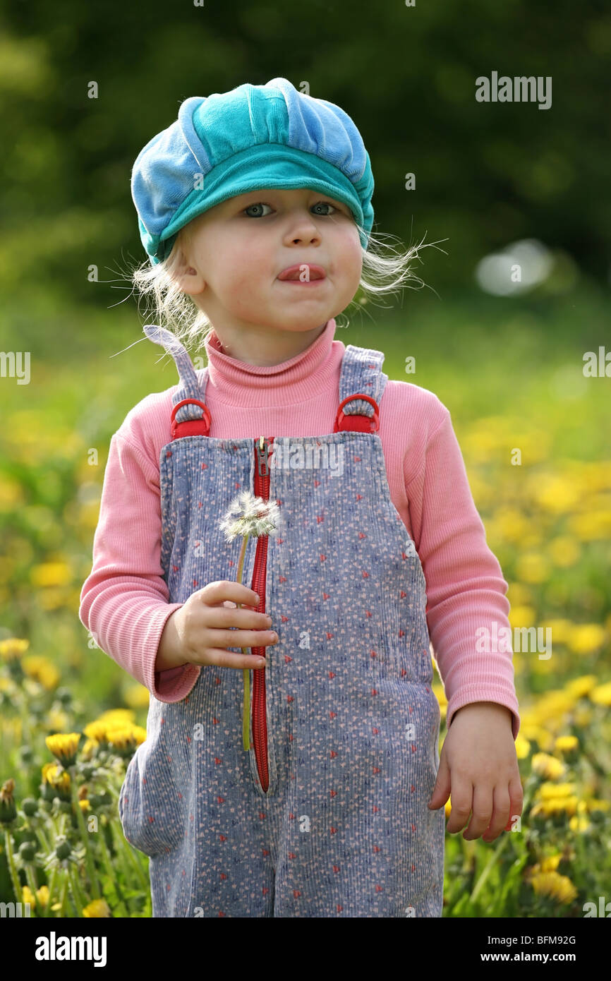 little girl in blue cap on a beautiful summer meadow Stock Photo - Alamy