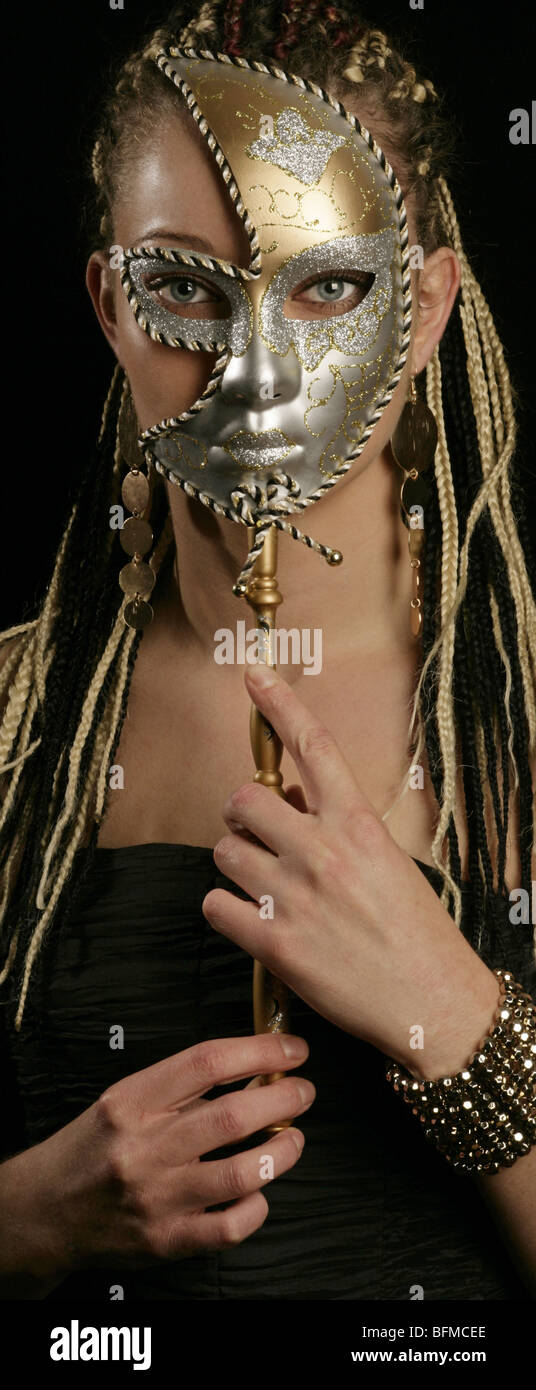 young beautiful woman with braided hair wearing a venetian mask as a ...