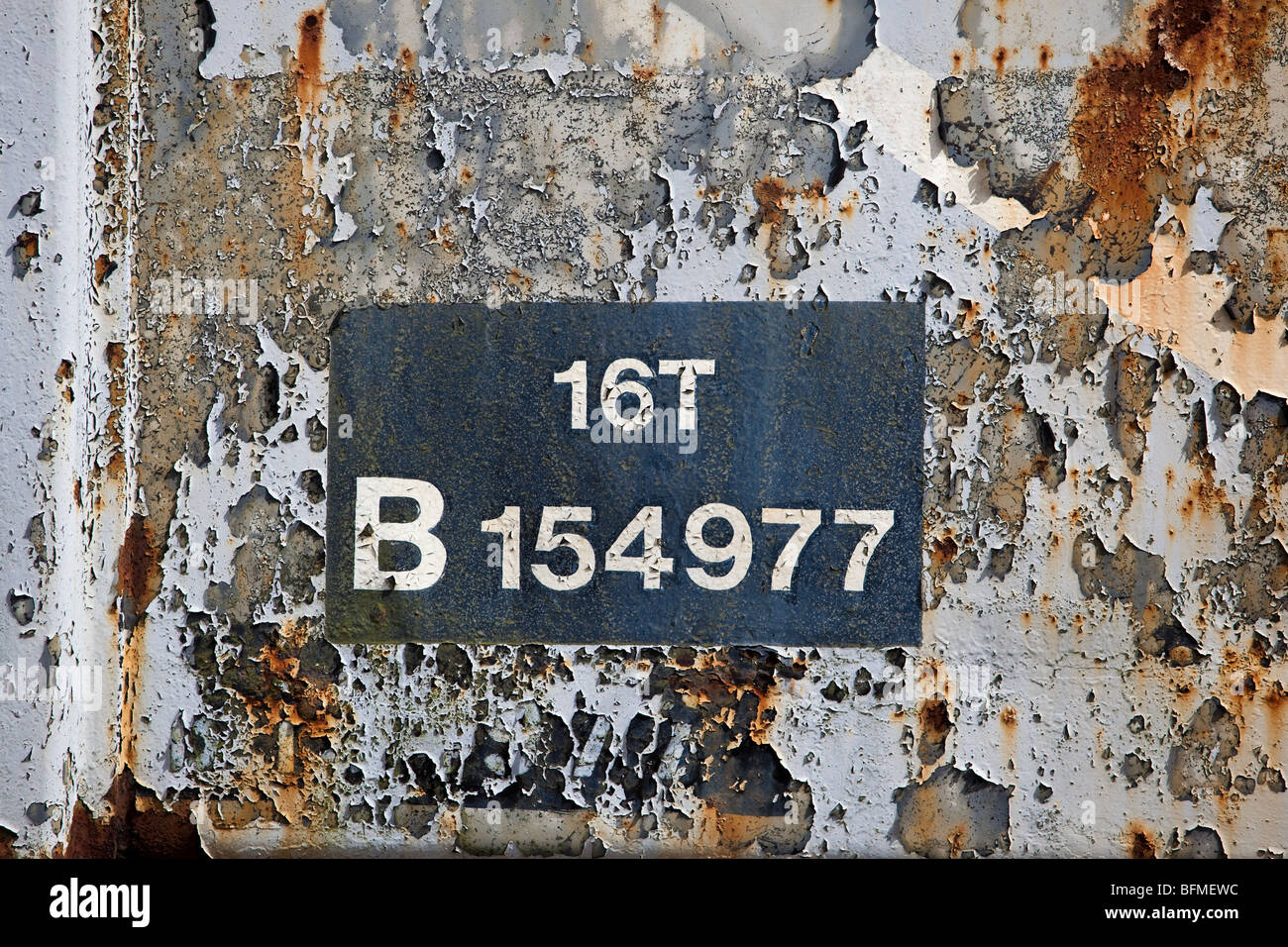 Worn sign "16T B154977" attached to decaying textured wall Stock Photo ...
