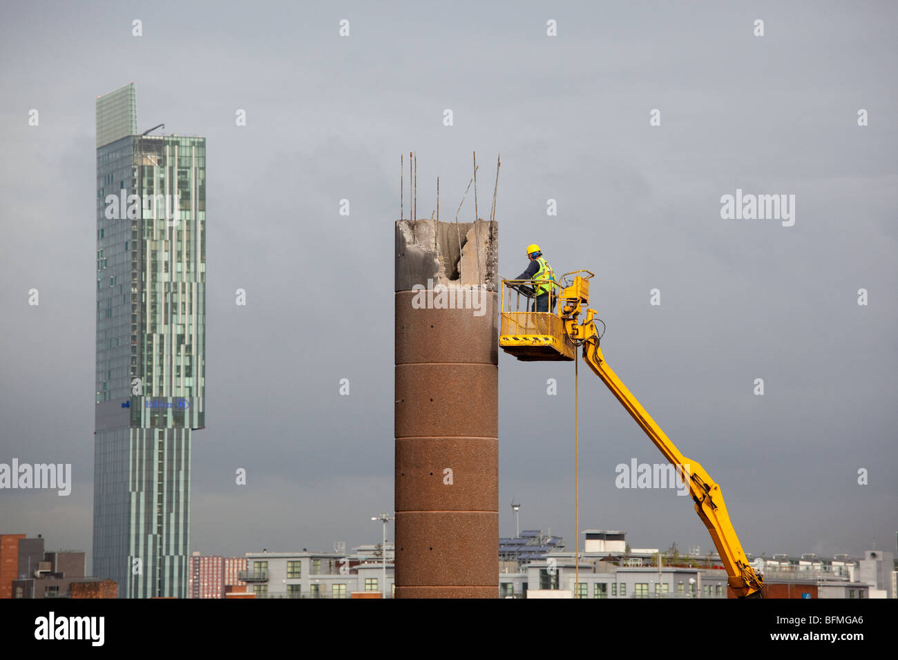 Workman drilling cooling tower from crane during demolition on Booth ...