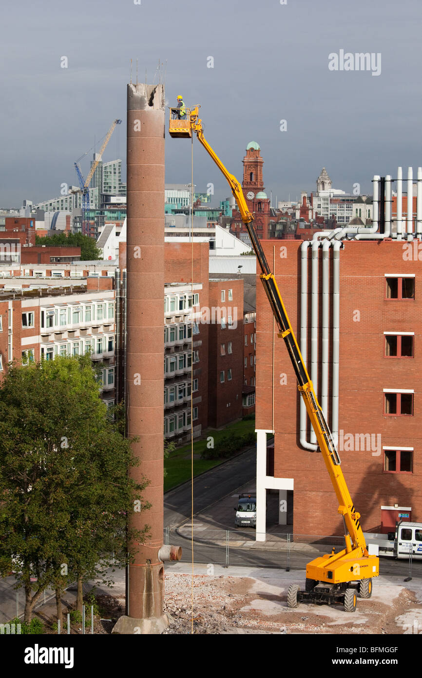 Workman drilling cooling tower from crane during demolition on Booth ...