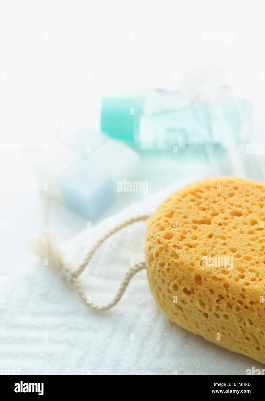 Bath sponge, bar of soap and bottle on towel Stock Photo - Alamy