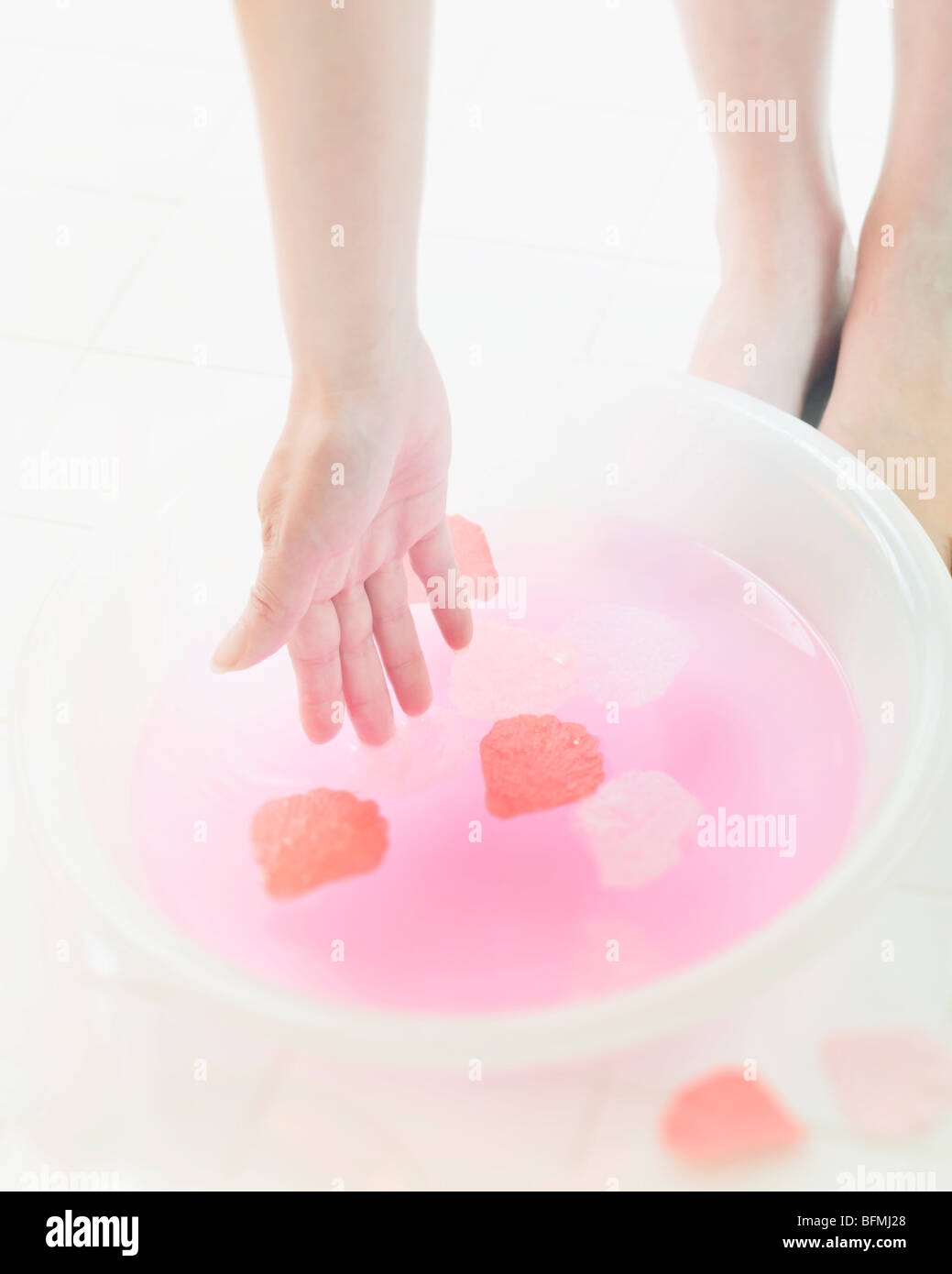 Woman touching flower petals in bowl of water Stock Photo - Alamy