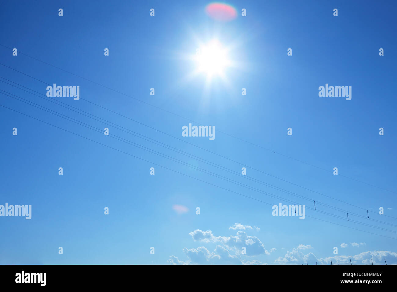 Sun and power lines in blue sky, blue background Stock Photo - Alamy