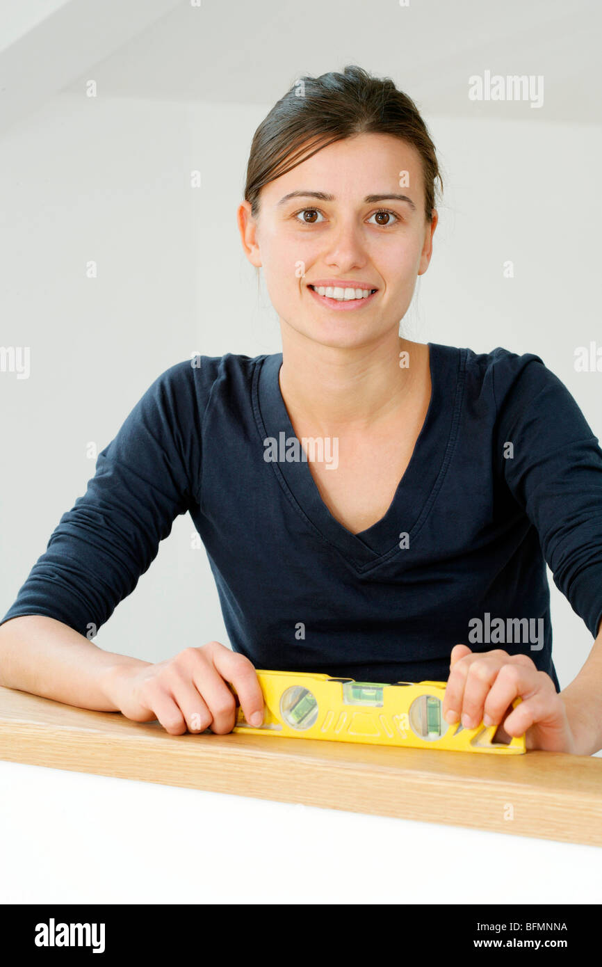 Woman holding a spirit level Stock Photo - Alamy