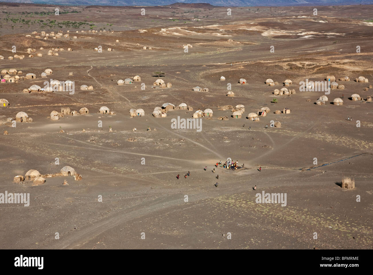 A communal water pump at Loiengalani with traditional domed houses ...