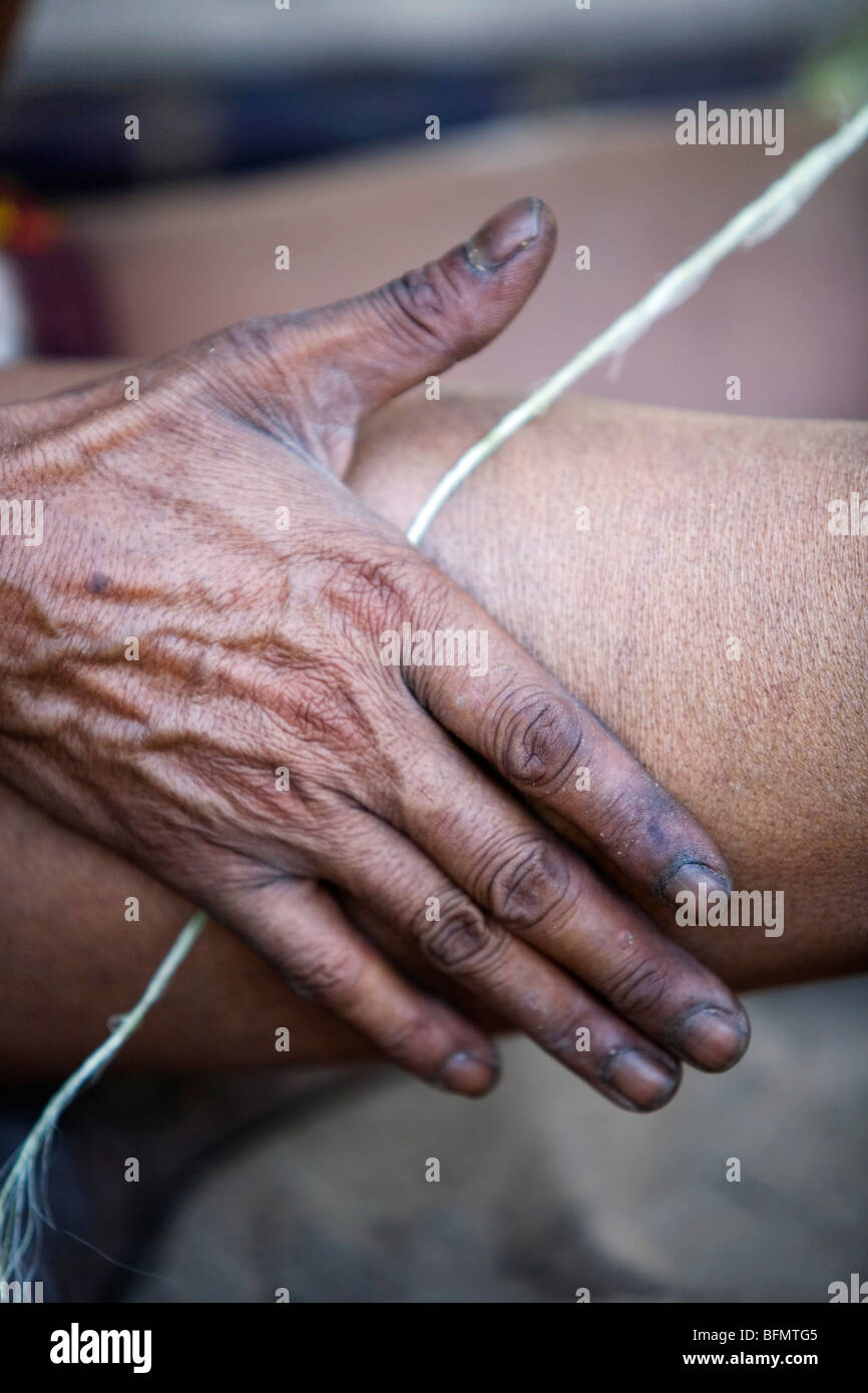 Bushmanland, Namibia. A San (Bushman) hunter twining string (made from ...