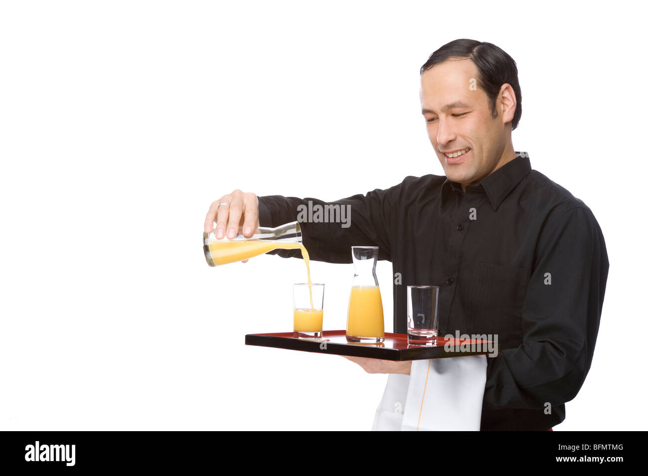 Male waiter smiling and pouring orange juice Stock Photo - Alamy