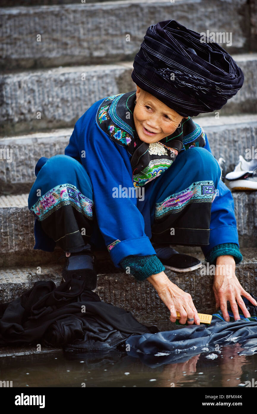 China, Hunan Province, Fenghuang, a woman washing clothes in a river ...