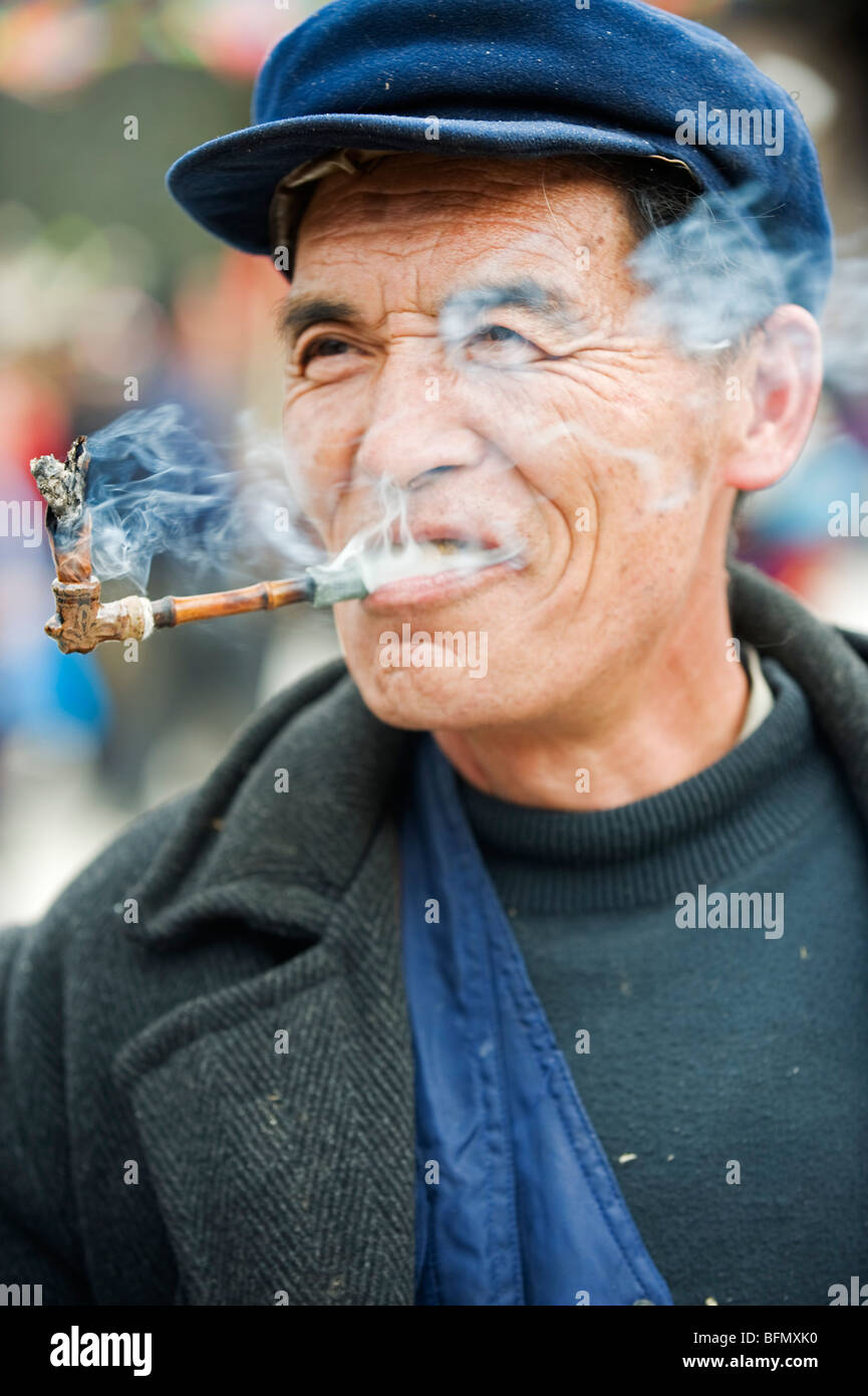 China, Guizhou Province, Qingman Miao village, a man smoking a pipe ...