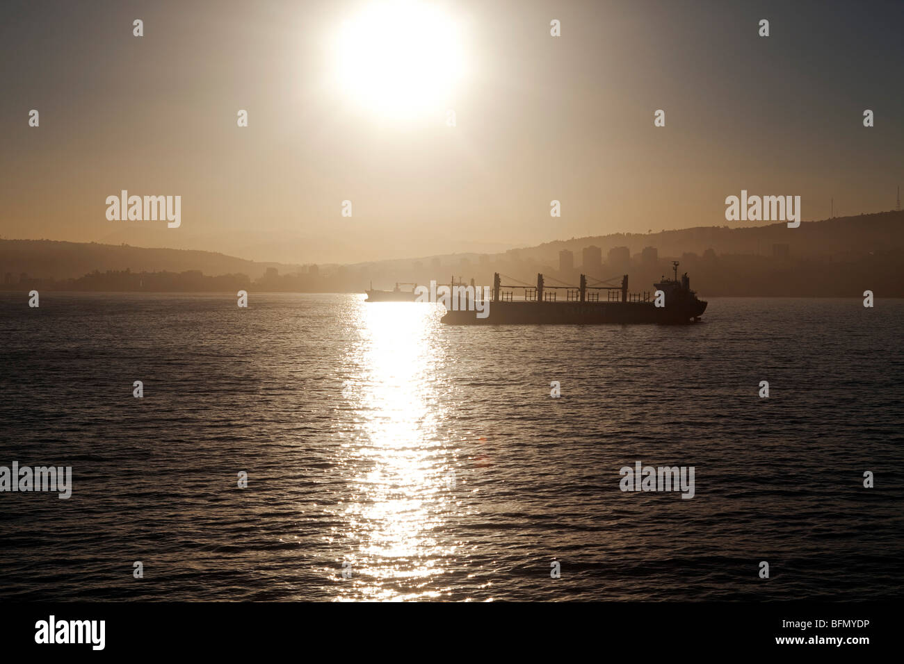 Chile, Port of Valparisio. At sunrise frieghters ride thier anchors at ...