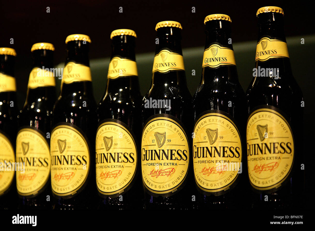 Ireland, Dublin, St James Gate, a line of bottles of Guinness stout ...