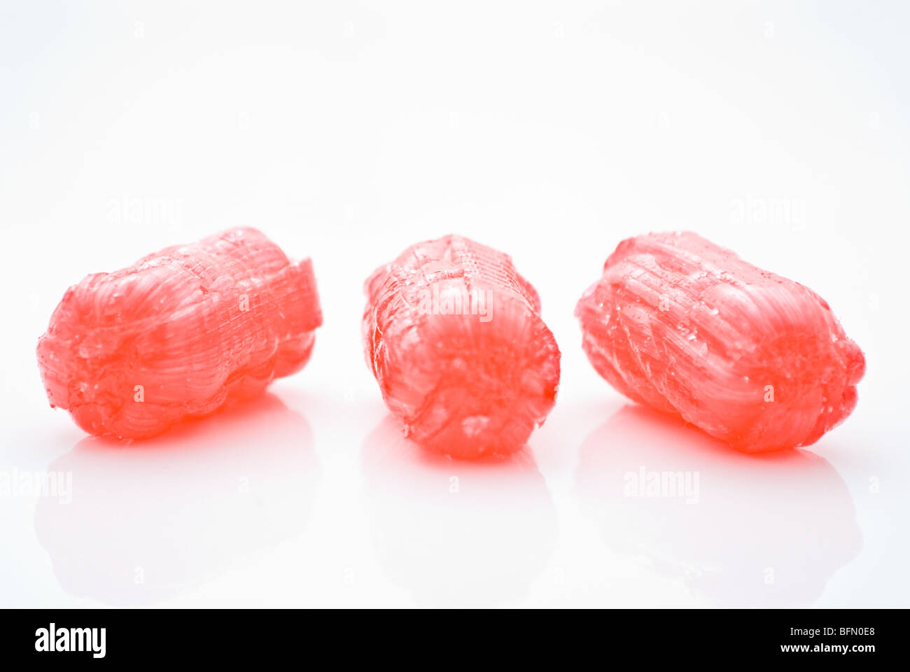 Red sweets on white background with reflection Stock Photo - Alamy