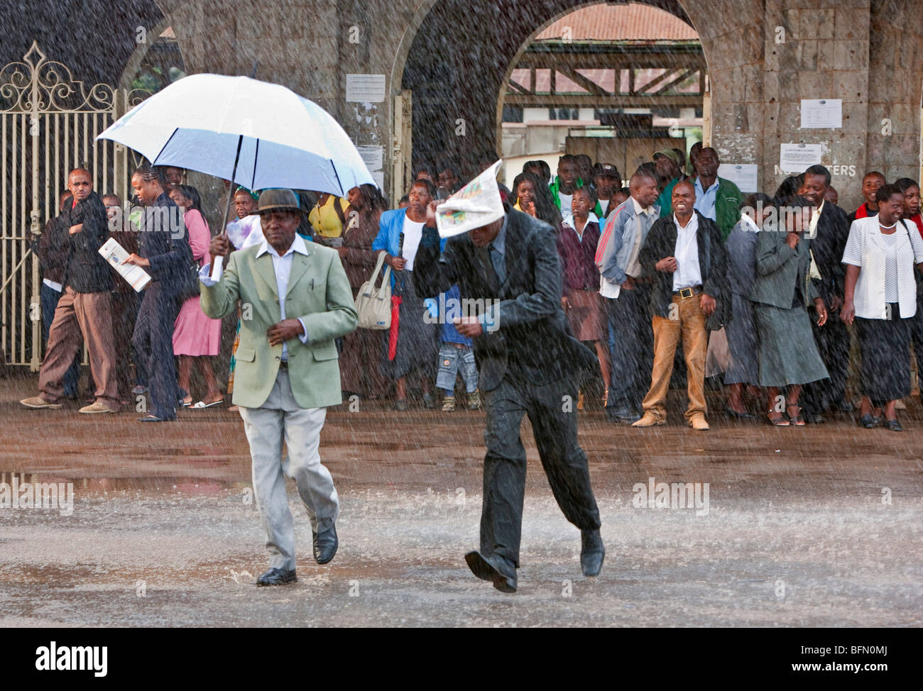 Kenya, Nairobi. Commuters brave the rain at Nairobi Railway Station ...