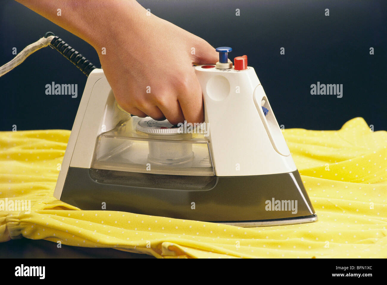 Hand ironing cloth using electronic iron Stock Photo - Alamy