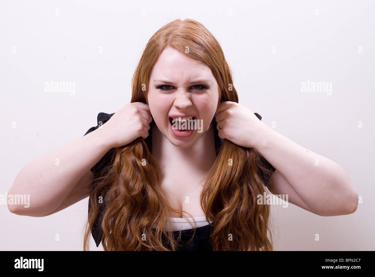 Mad young woman pulling hair and shouting Stock Photo - Alamy