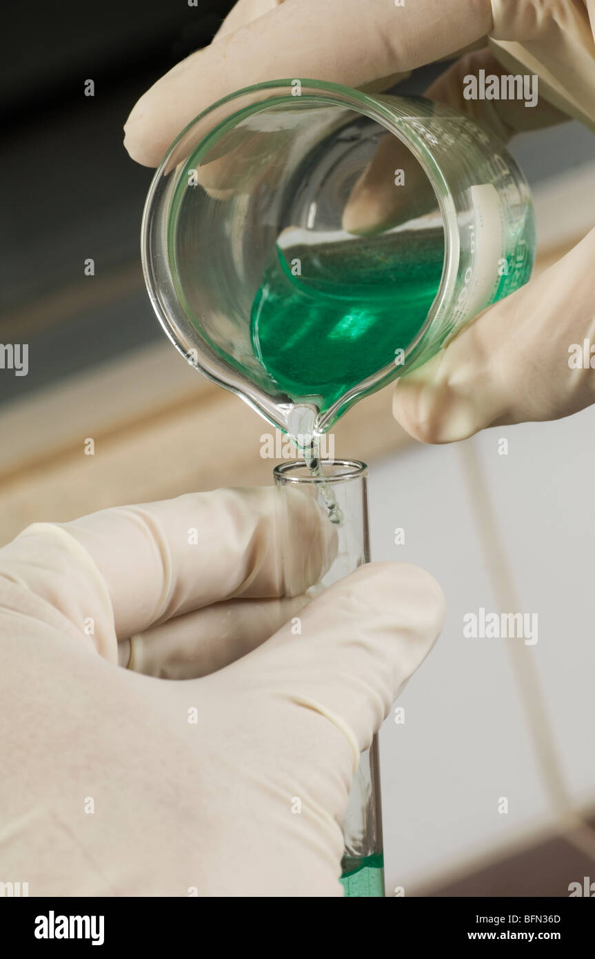 Scientist mixing fluids in test tube Stock Photo - Alamy