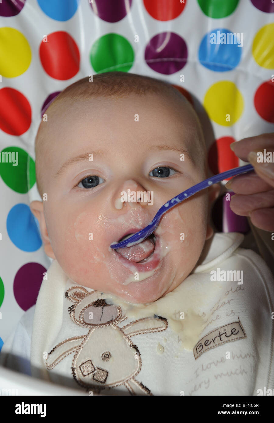 Four month old baby boy being spoon fed with his first solid food uk ...