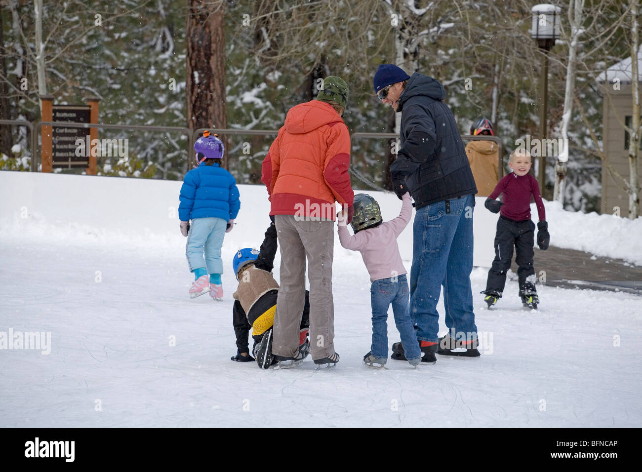 A family goes ice skating on a family outing at an ice rink in Bend ...