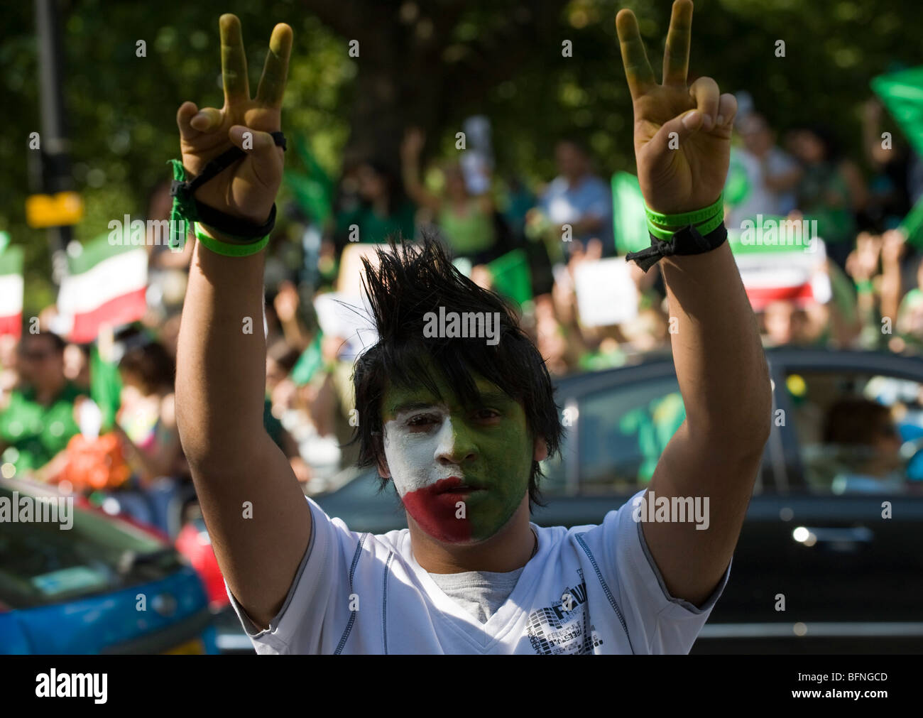 Young man with his face painted in the colours of the iranian flag at ...