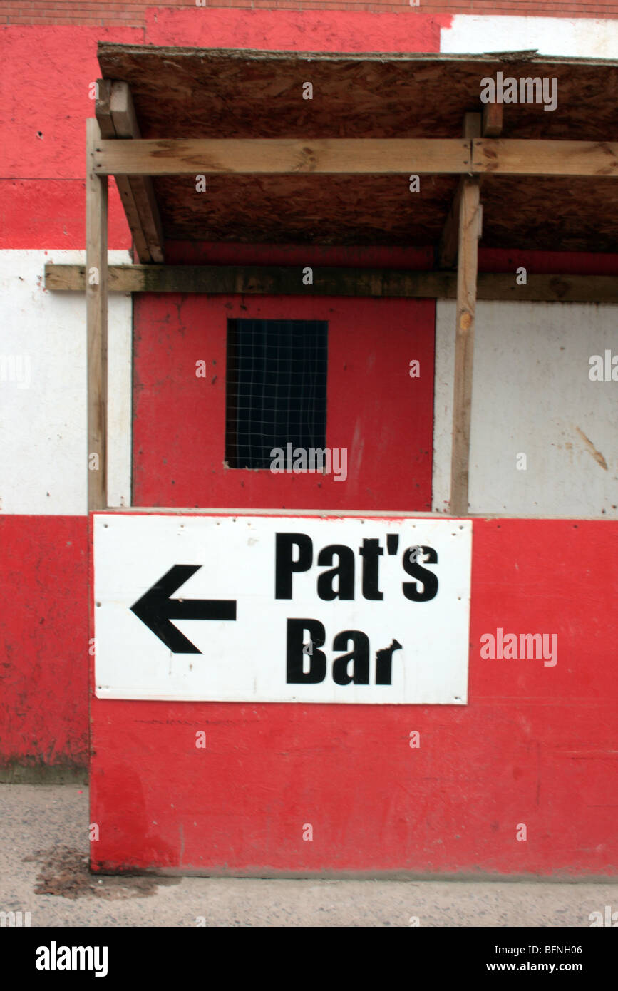 Pat's Bar street sign on a hoarding in front of a building site of the ...