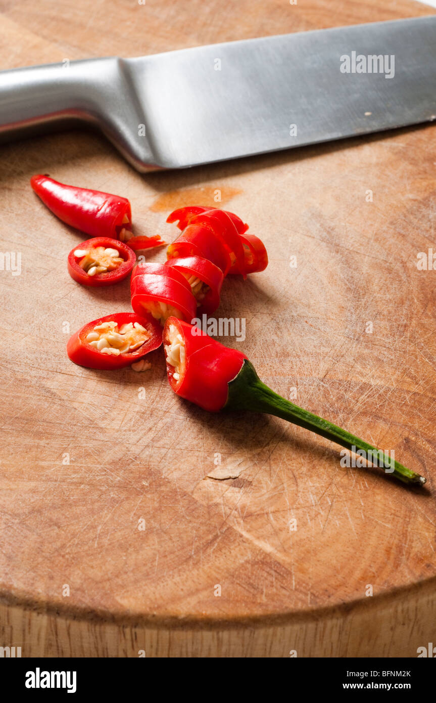 Sliced red chilli on chopping board with knife Stock Photo - Alamy