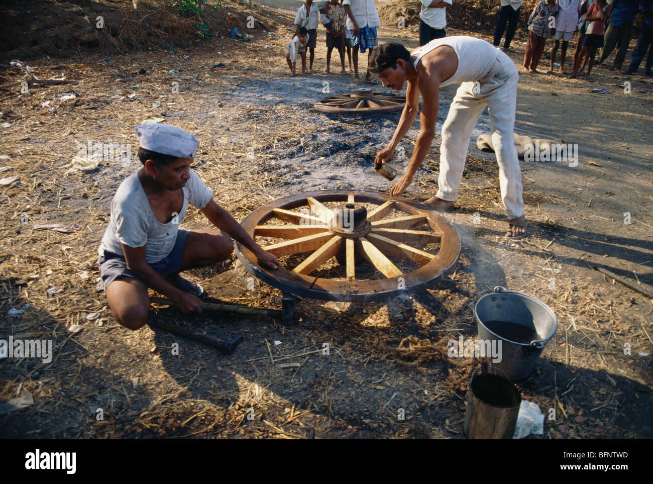 Bullock cart wheel making ; putting iron around wheel ; Maharashtra ...