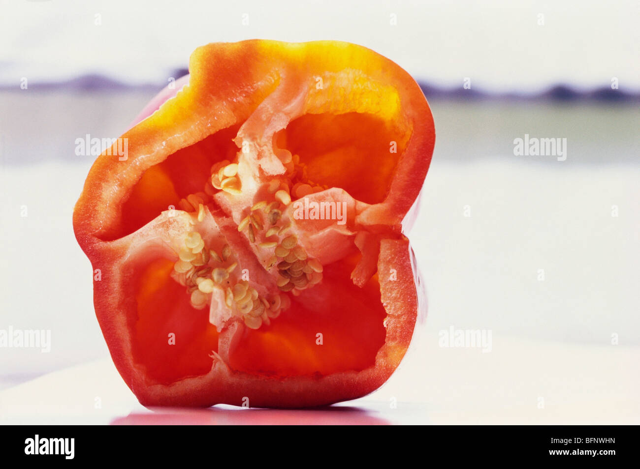 half cut red capsicum on white background Stock Photo - Alamy