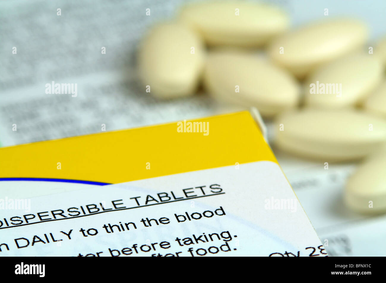 tablets by a box of tablets with a blurred prescription as background ...