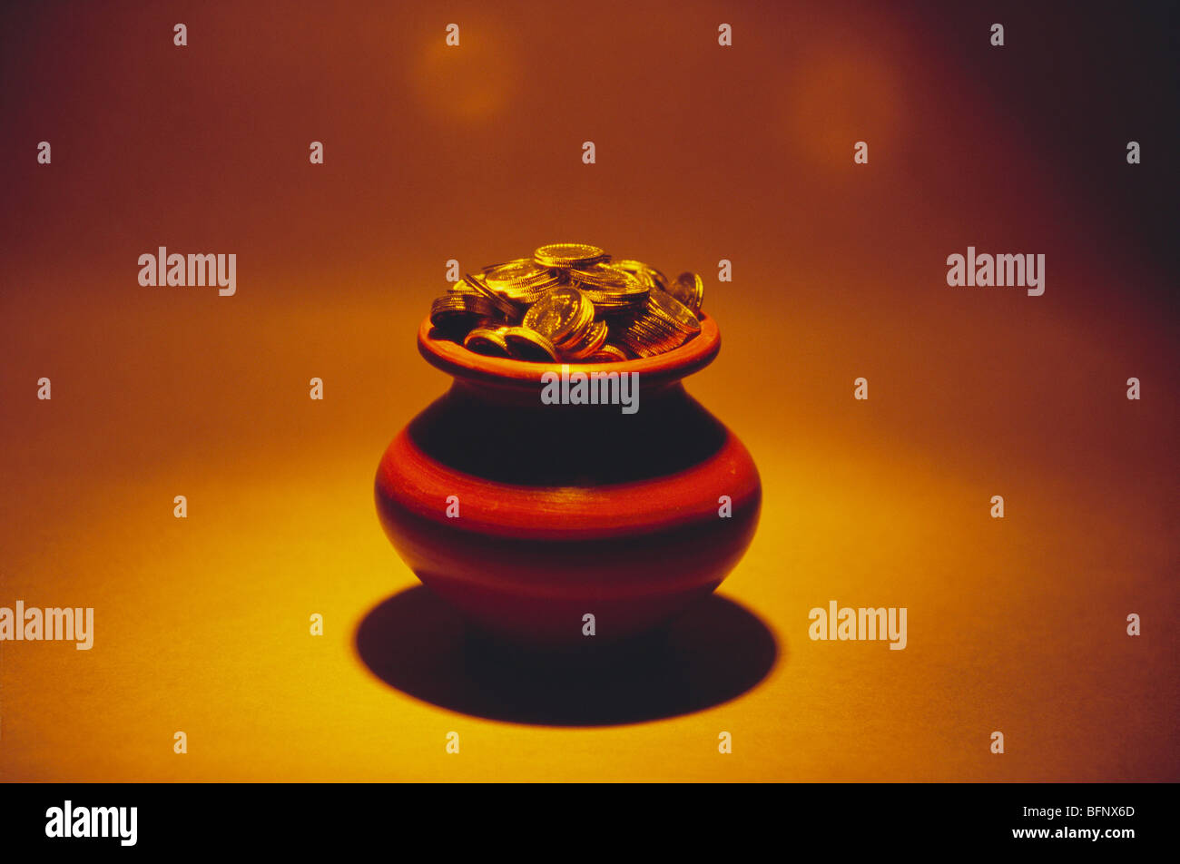 Coins in pot Stock Photo - Alamy